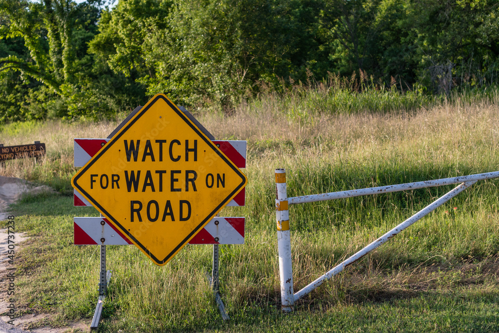 Sign reading "Watch for Water on Road" sign due to flooding caused by ...