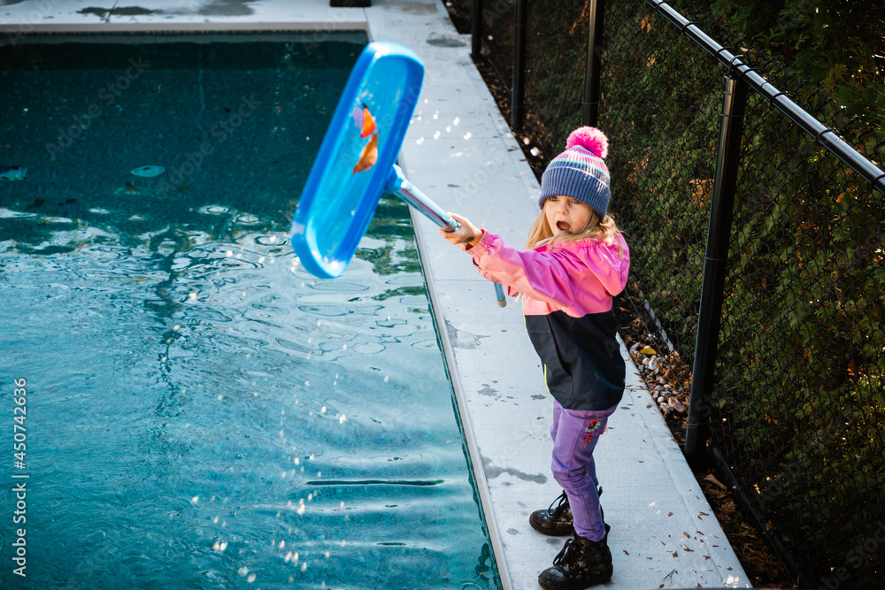 5 years old girl cleaning the swimming pool during fall Stock Photo ...