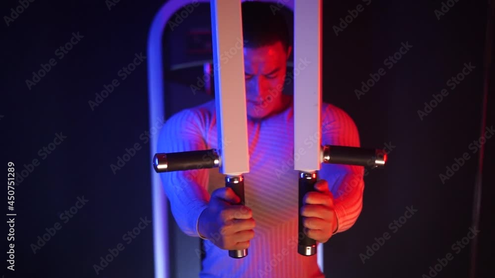 Moving around Asian man doing butterfly chest exercise on machine ...