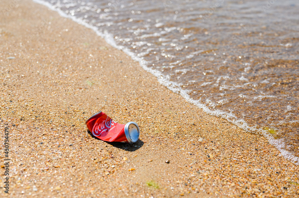 Anapa, Russia-August 2021: An empty crumpled can of Coca-Cola lies on ...