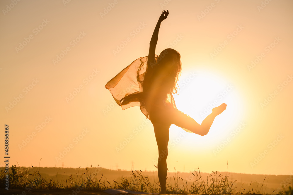 Dancing girl silhouette in warm sun light with transparent cloth ...