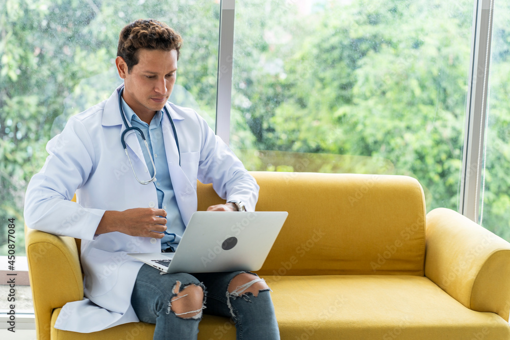 Handsome doctor works reading patient reports from laptop and patient ...