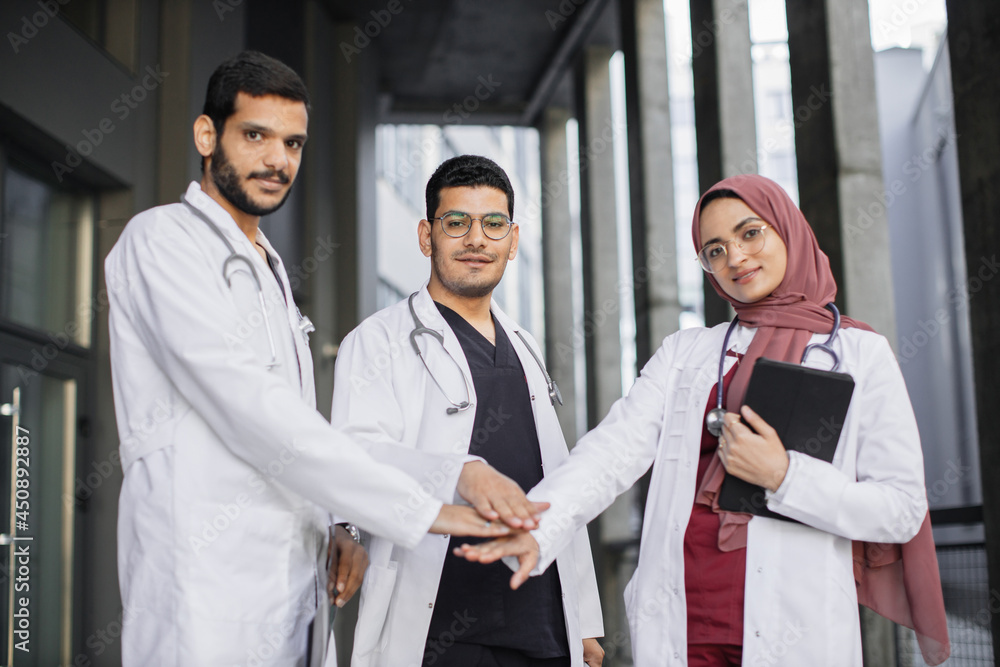 Motivated medical team of three Arab doctors, showing their unity and ...