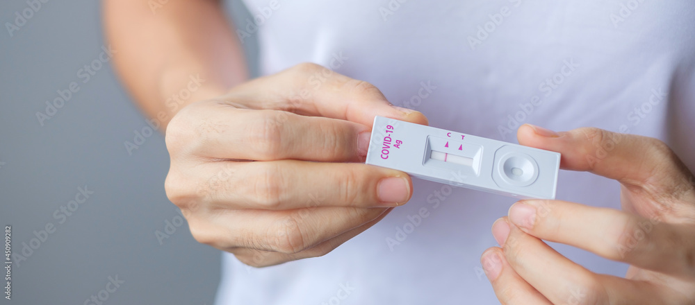 man holding Rapid Antigen Test kit with Negative result during swab ...