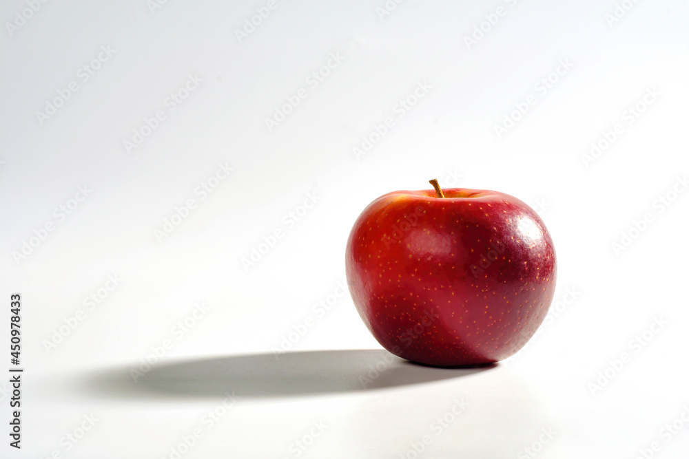 a fresh red apple isolated in graduated white background with back ...
