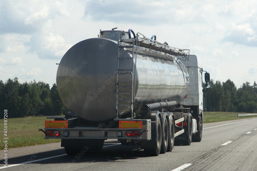 Gray barrel semi truck back side view on left lane drive on the ...