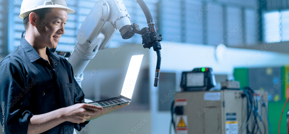 Engineer working with robot arm in factory modern production line ...