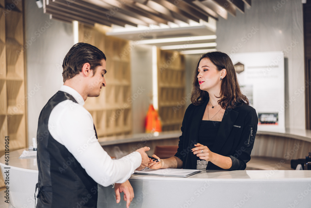 Young handsome businessman talking and check in register information ...
