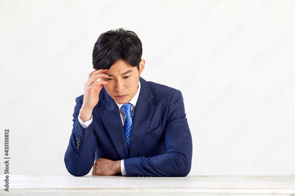 흰 배경 앞에 정장 입은 고민하는 30대 한국 남자 스톡 사진 | Adobe Stock