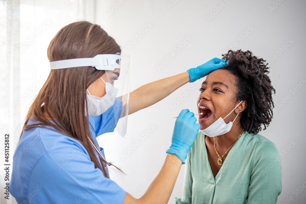Close up of female health Professional in PPE introducing a nasal swab ...