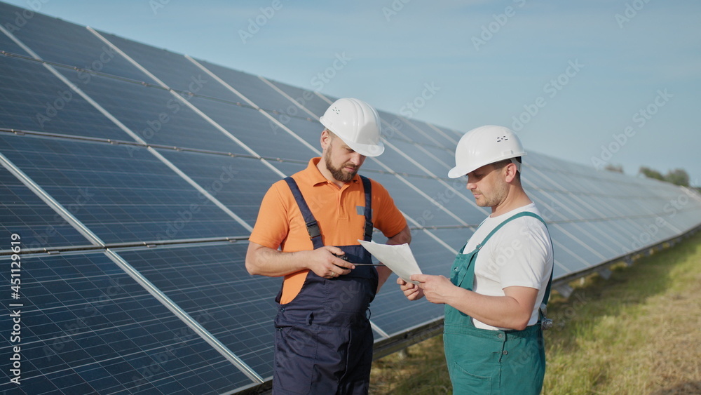 Technician of energy checking the solar cell panels at solar farm ...