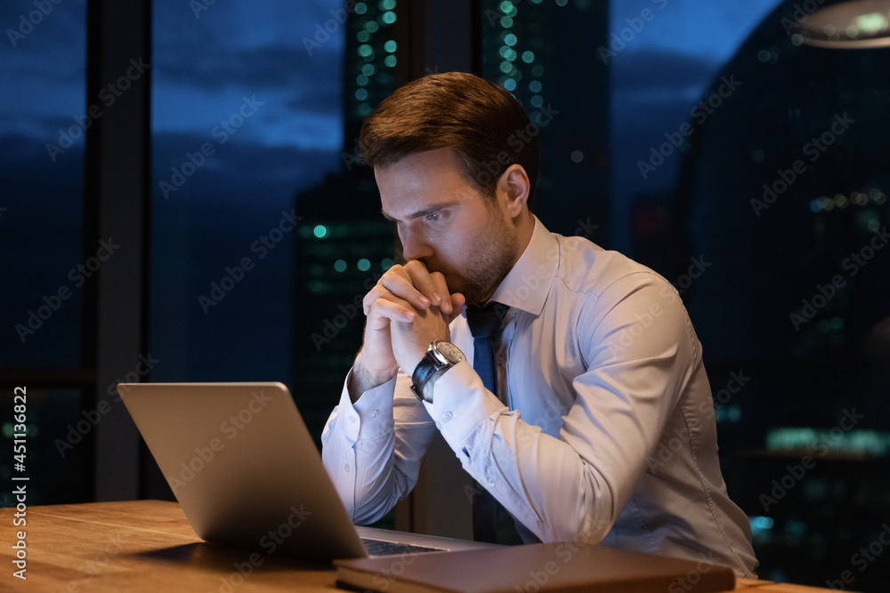 Businessman sit at workplace do overtime work until late using computer ...