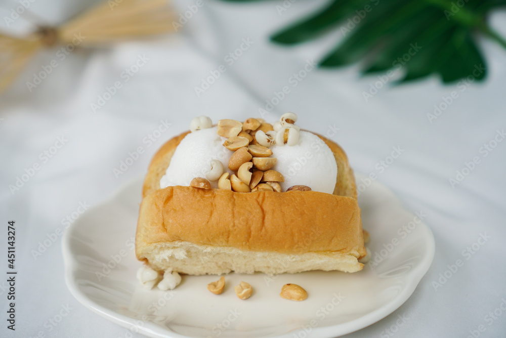 Coconut ice cream with bread. A soft bread topped with two scoop of ...