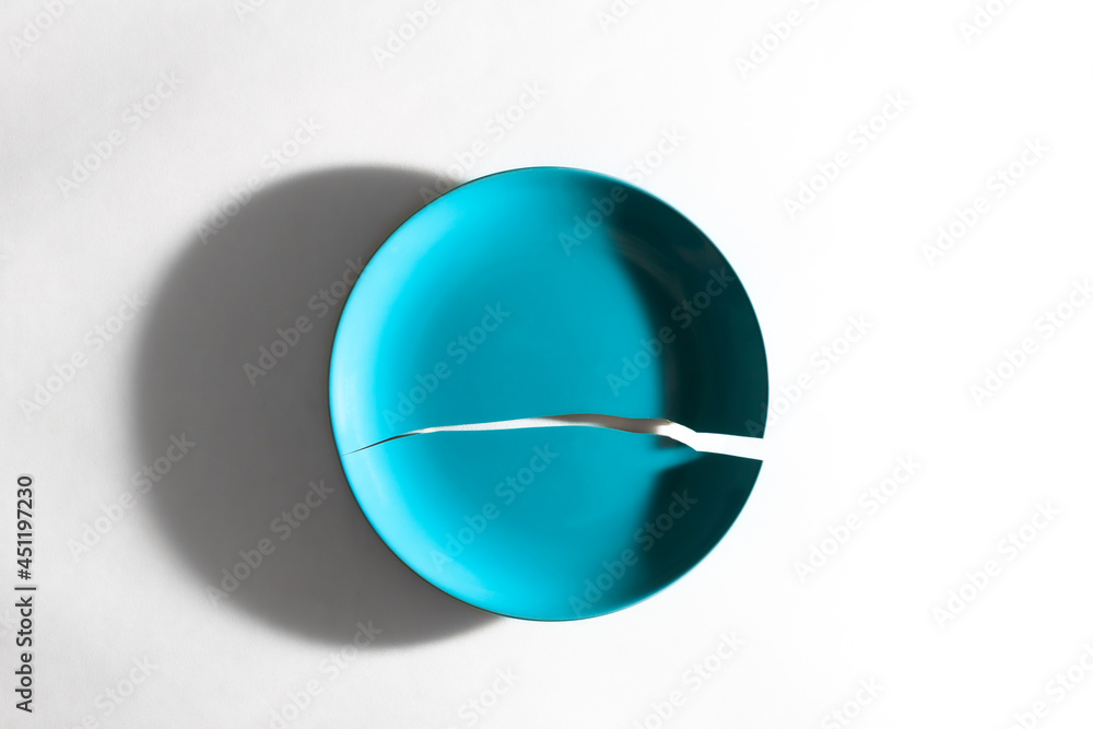 Crack in blue plate on white background, rift between two parts of ...