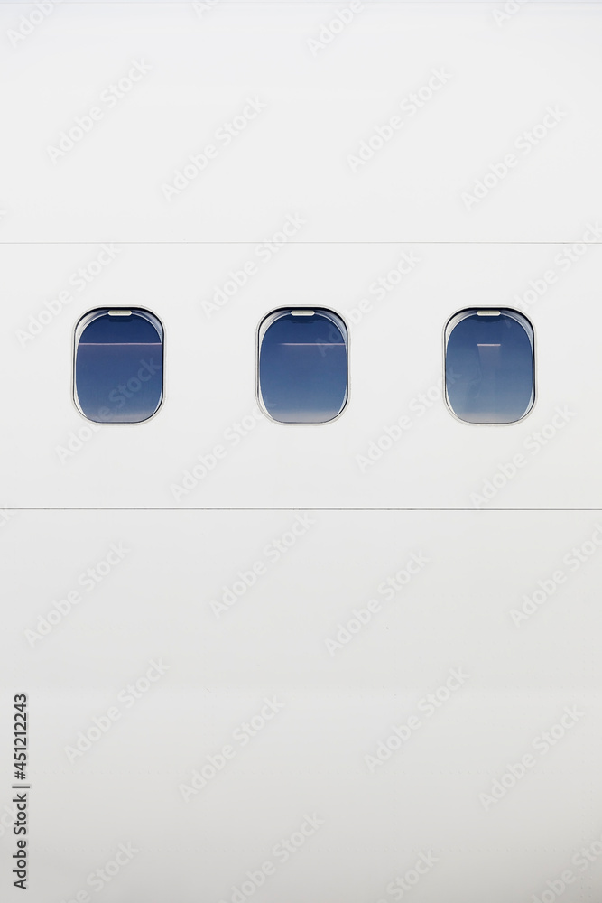 Three windows on fuselage of white airplane. Vertical image of plane ...