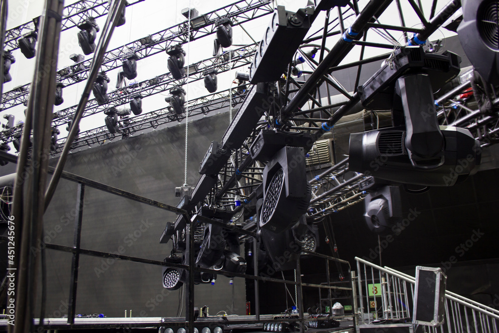 Moving head spotlight devices are clamped on a rigging steel trusses ...
