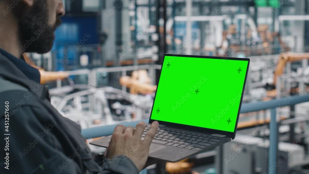 Car Factory Engineer in Work Uniform Using Laptop Computer with Green ...