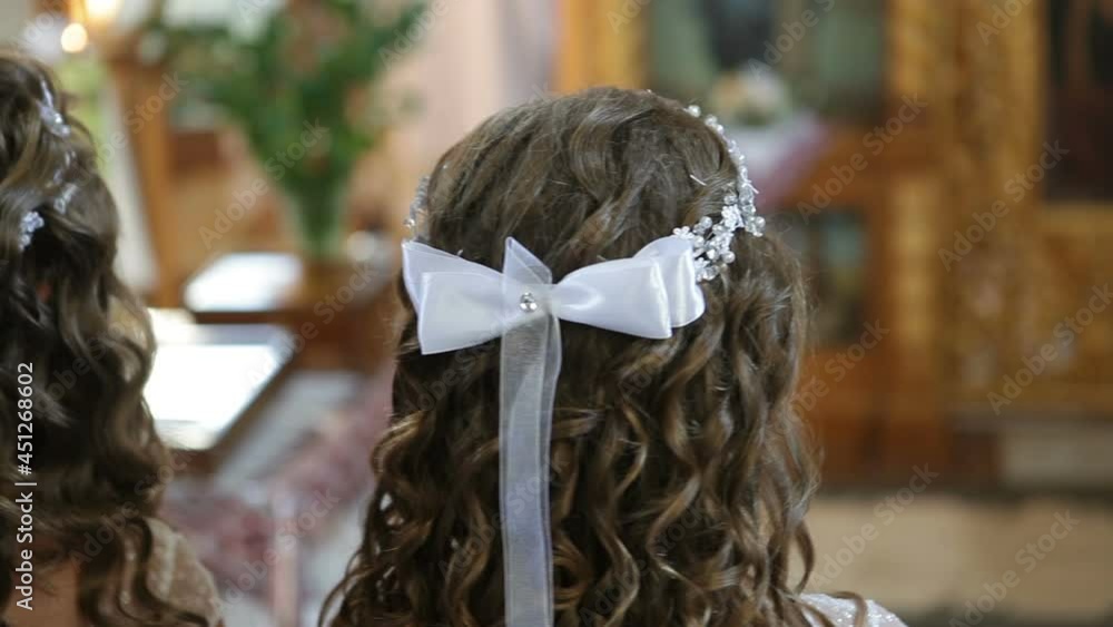Girls stand in church for their first communion,rear view.Girls have ...
