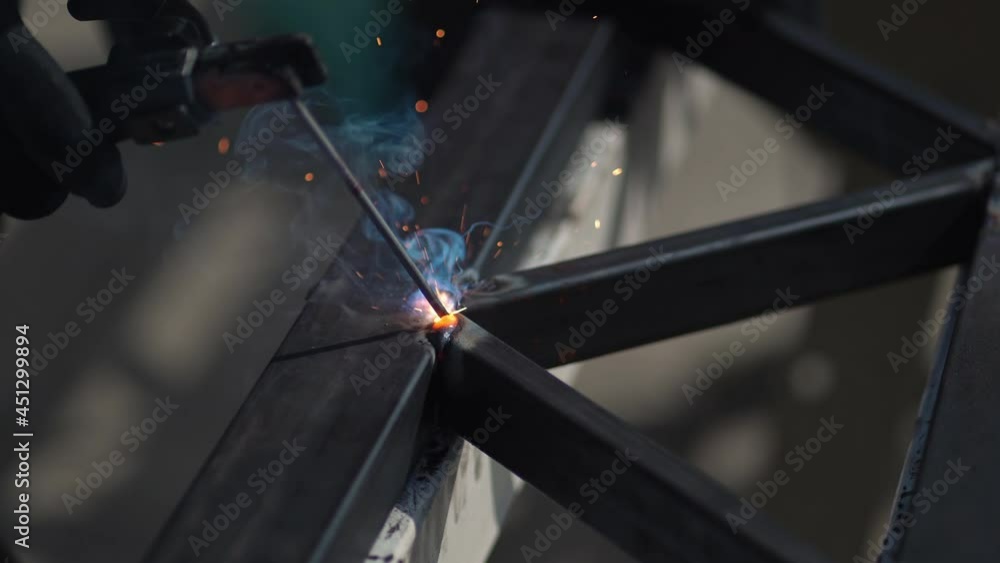 Employee man welding steel with sparks using mig mag welder, sparks ...