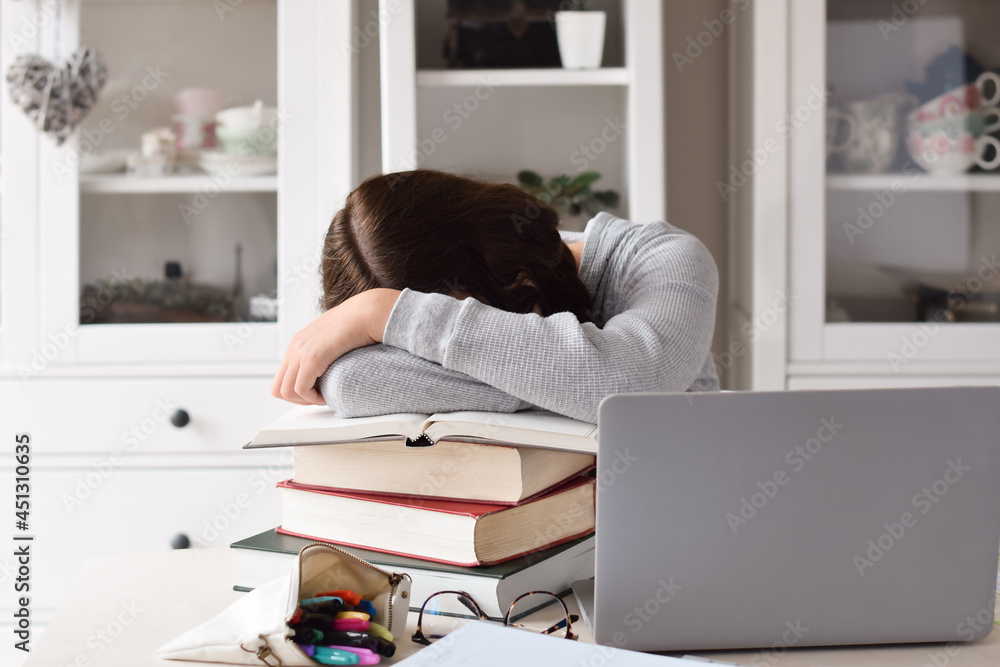 Foto de Young girl student fell asleep on top of textbooks while ...