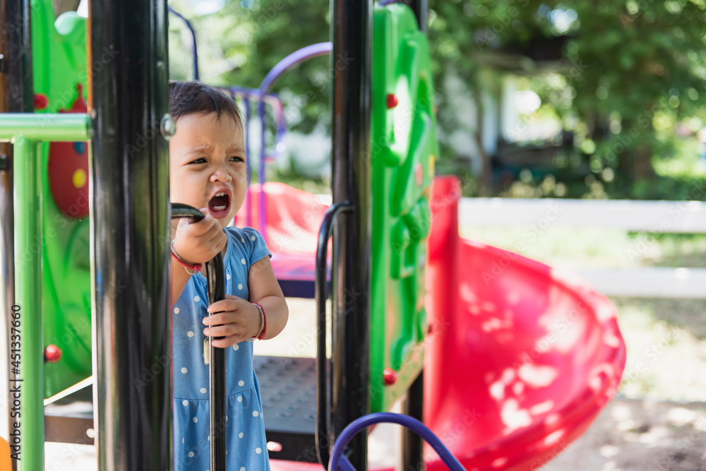 little girl playing in the spring playground child crying outside ...