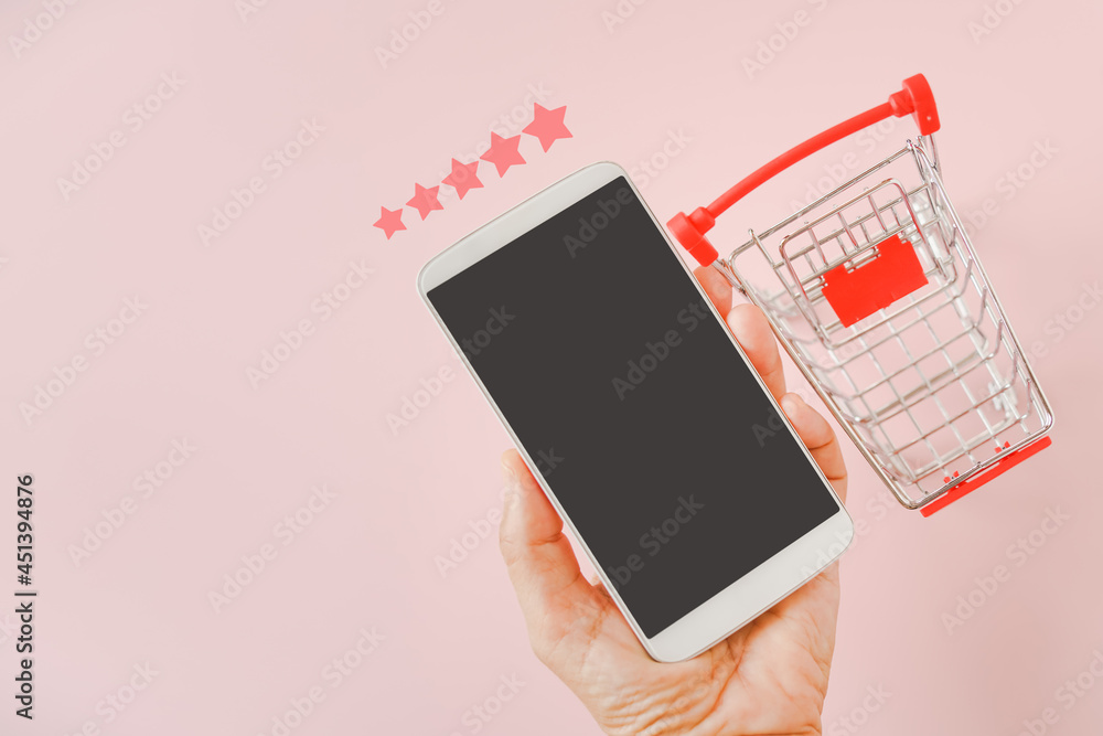 hand holding white mobile phone with clipping path and blurred shopping ...