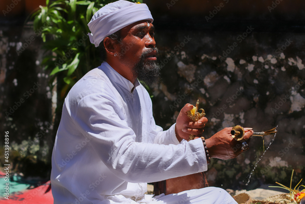 Close up of a Balinese pedanda during prayer. side view of a hindu ...