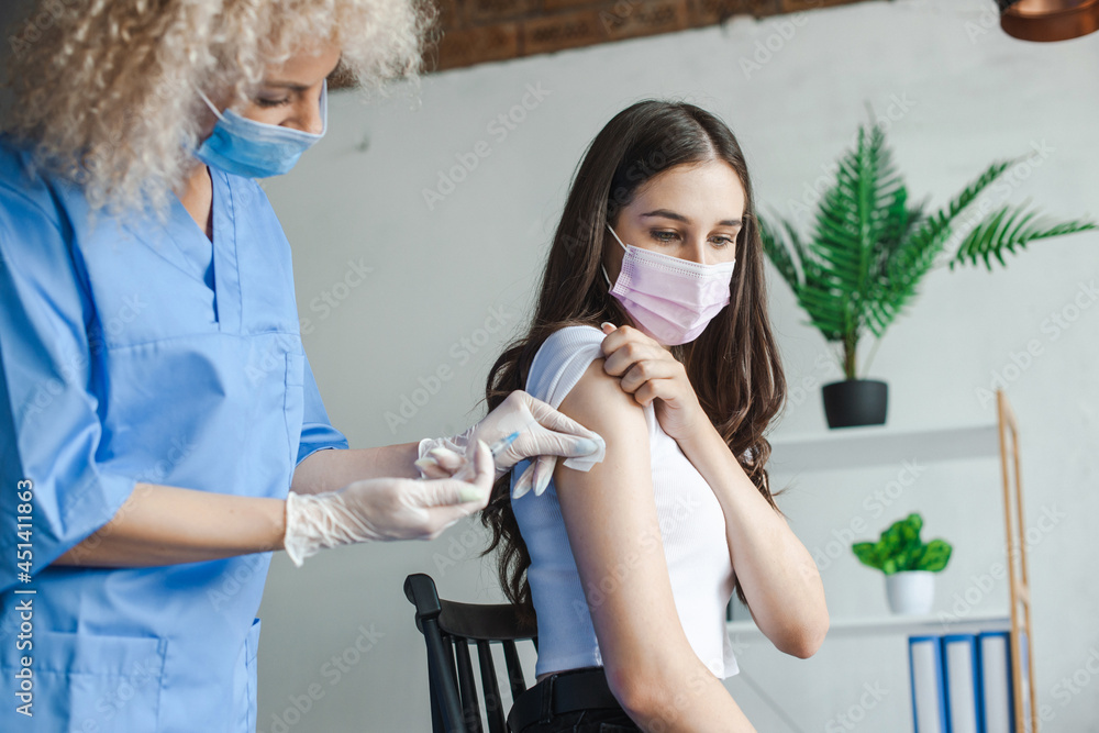 Woman getting vaccine from a doctor during immunization campaign ...