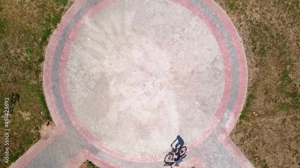 Top view bicycle woman riding a bike on round road in city park. Young ...