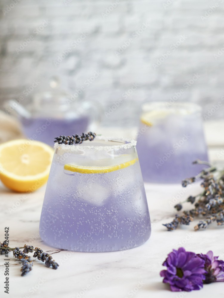 Glasses of fresh sparkling lavender-lemonade soda drink with salt&sugar on the edge of glass ...