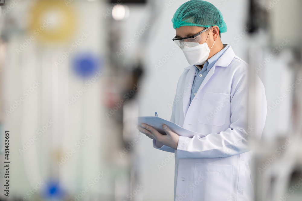 factory worker wearing medical face mask and checking production line ...