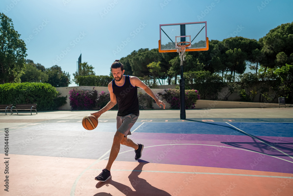 basketball player trains himself on a basketball court with a ball ...