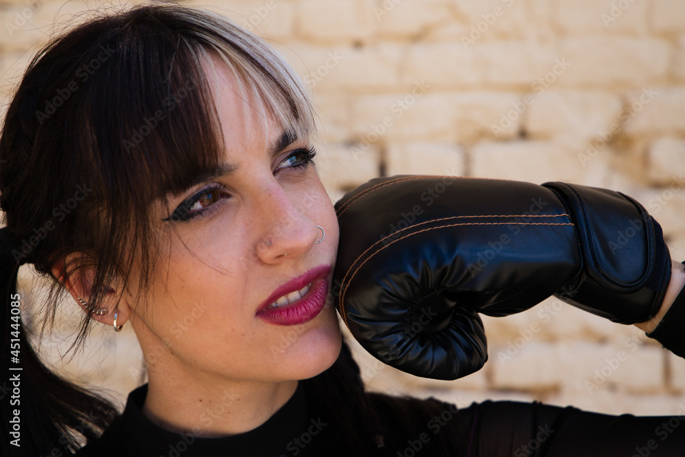 young and beautiful girl with a punky tendency. She is wearing boxing ...