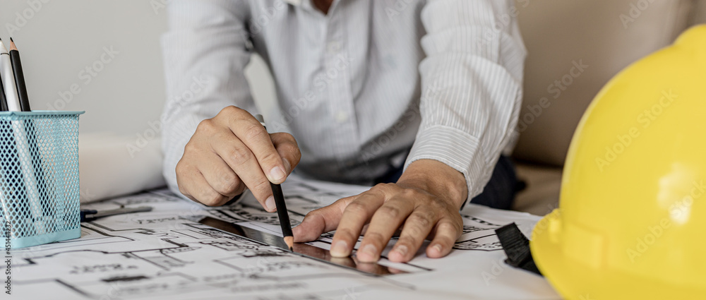 Architect uses a ruler to measure the blueprints of the houses he ...