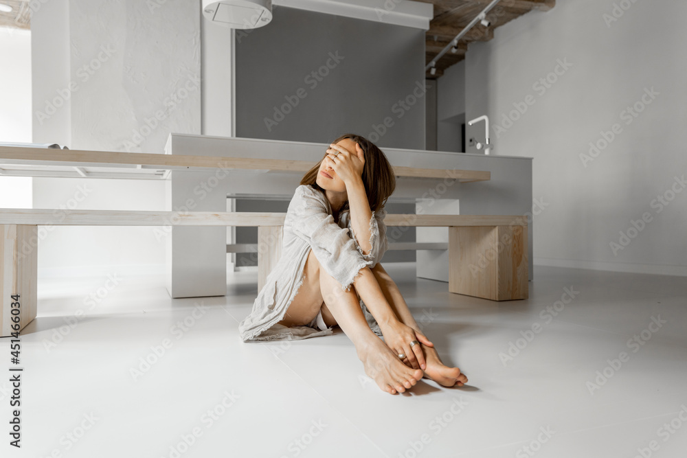 Young sad woman sitting depressed alone at home. Self-isolation and ...