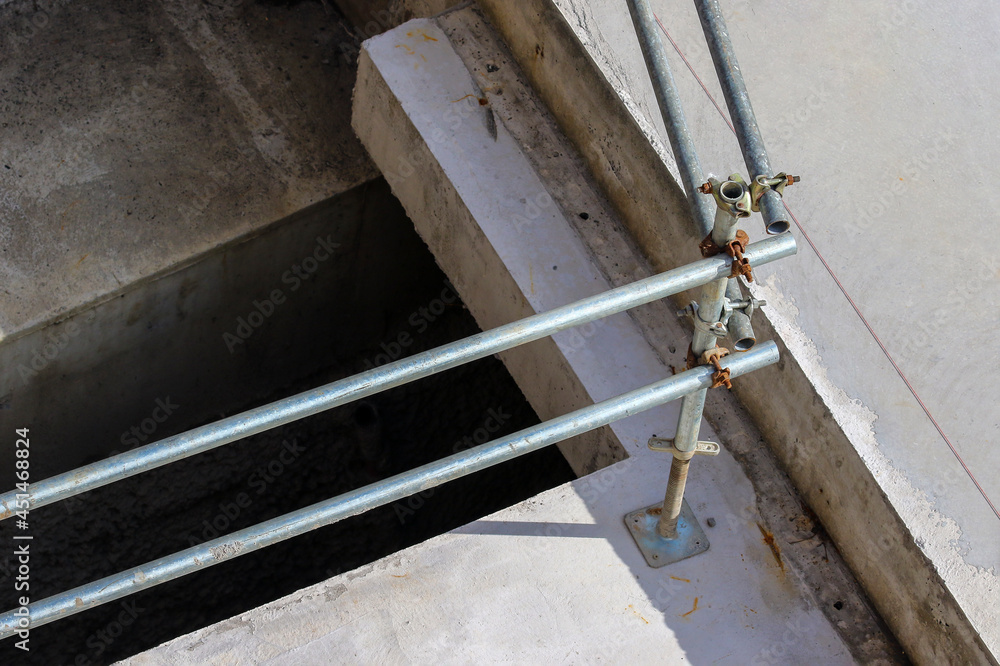 Tiered stepped concrete levels in construction site. Metal safety bar ...