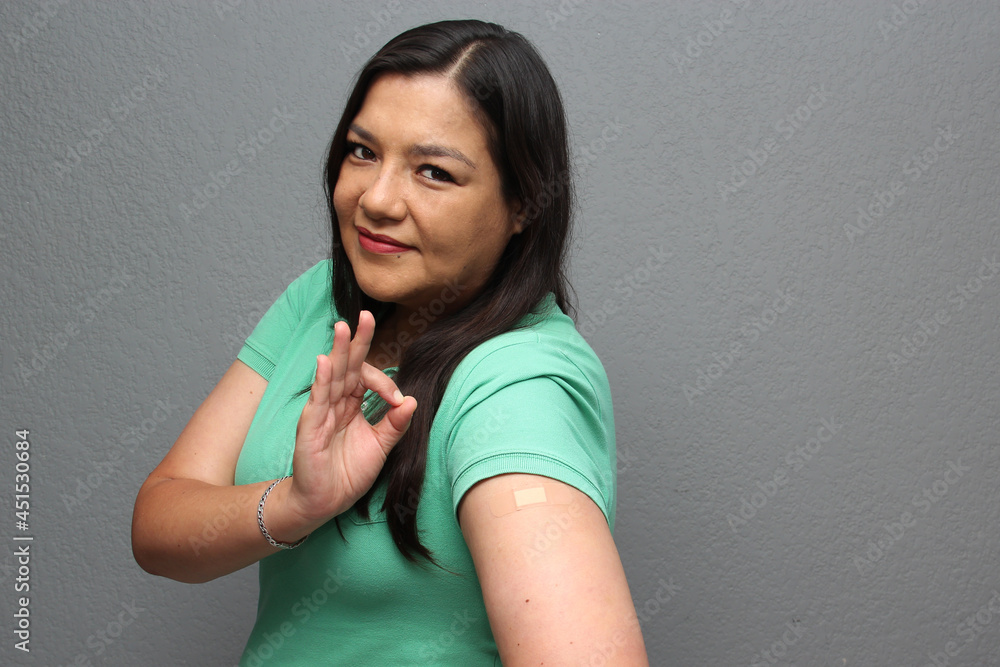 Adult Latina Woman Shows Her Arm That Just Received The Covid 19 adult-latina-woman-shows-her-arm-that-just-received-the-covid-19