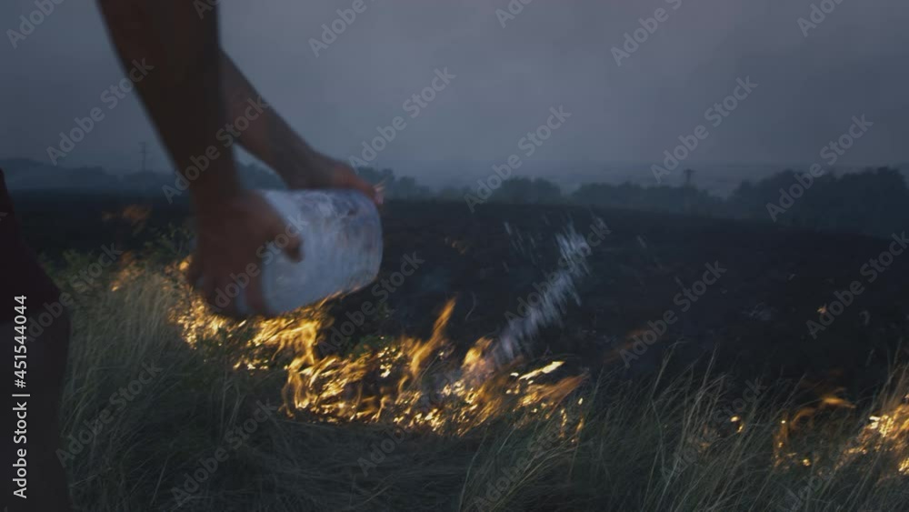Vídeo do Stock: A volunteer man or boy extinguishes a wild fire. Pours ...