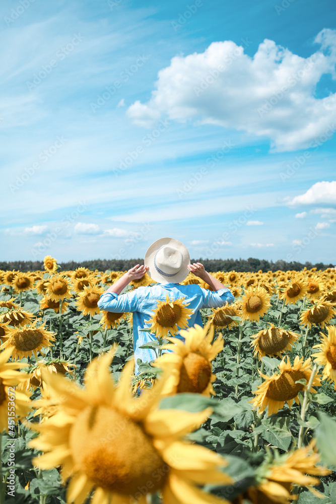 Summer concept. Female person with sunflower enjoying nature and ...