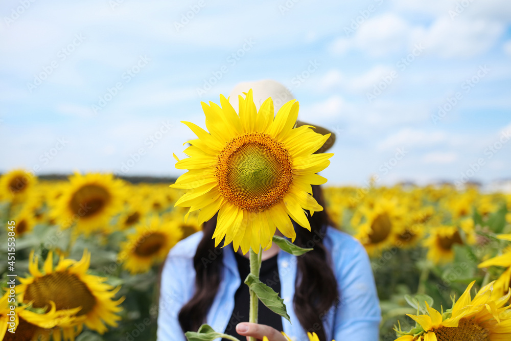Summer concept. Female person with sunflower enjoying nature and ...