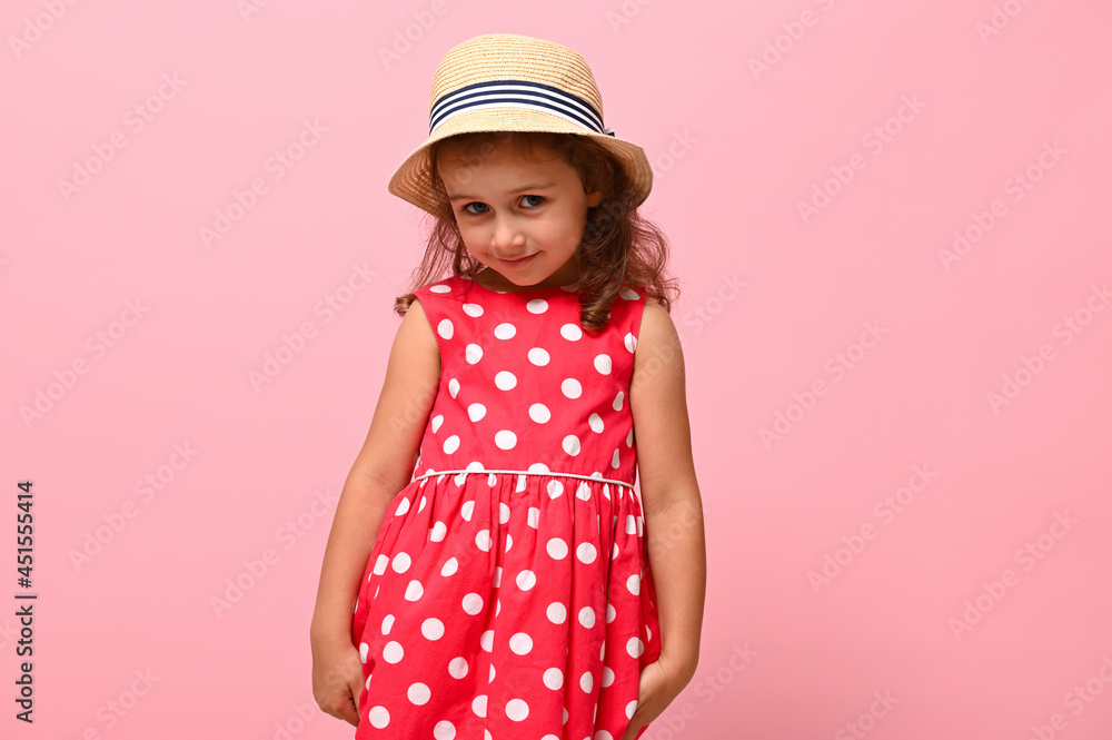 Pretty girl in a pink summer dress with white polka dots and a straw ...
