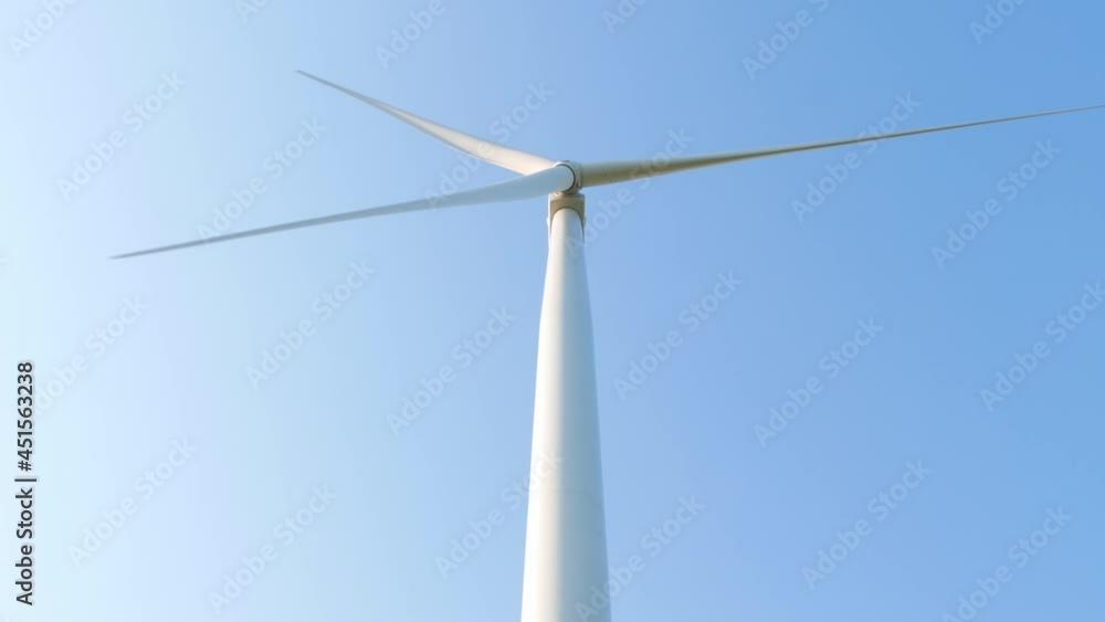 Wind turbine rotating on clear blue sky background. Local eco friendly ...