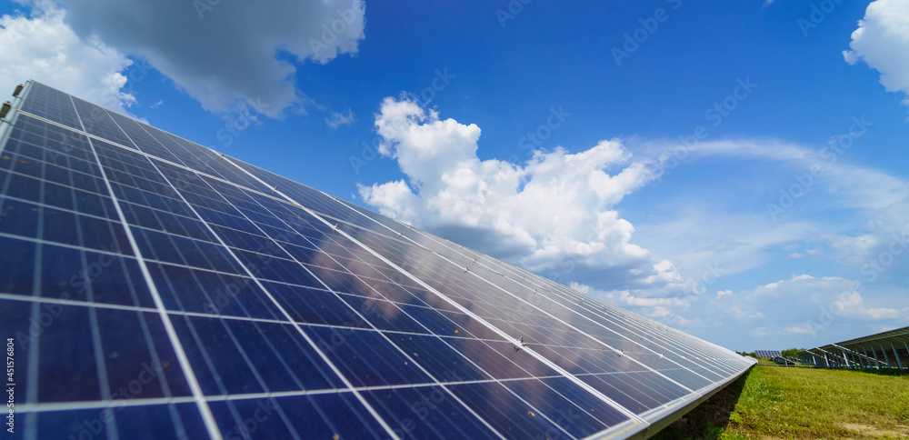 Solar panel on blue sky background. Green grass and cloudy sky ...