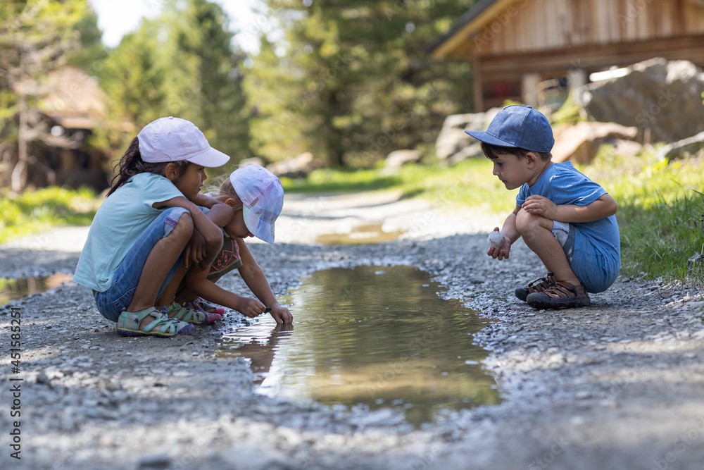 Kids playing outside in a puddle of water Stock Photo | Adobe Stock