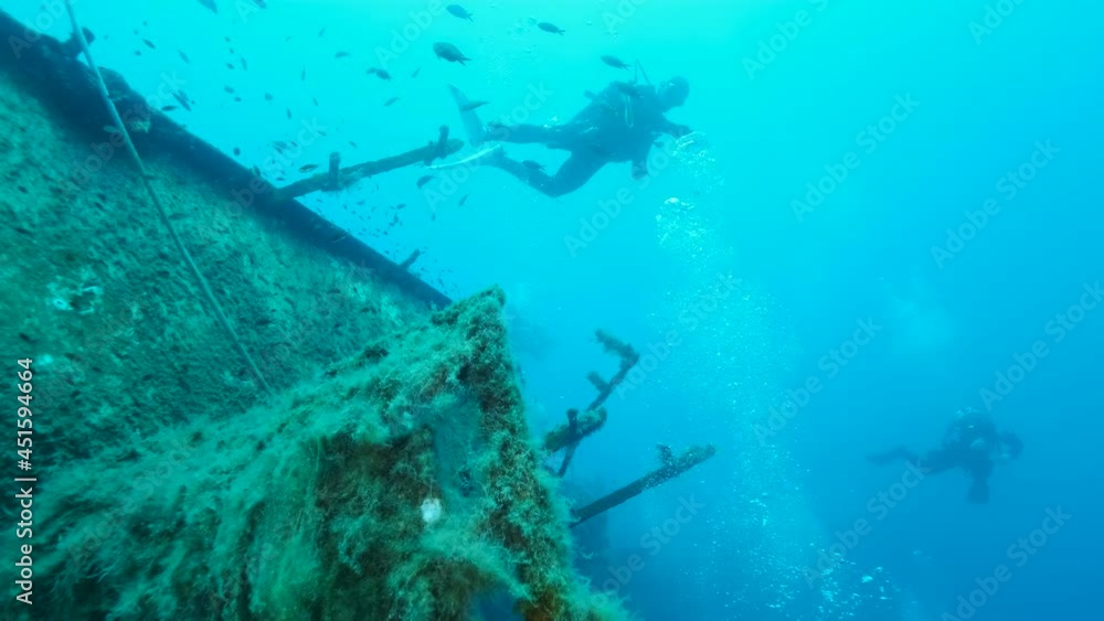 Group of scuba divers photographer swims on the shipwreck Swedish ferry ...
