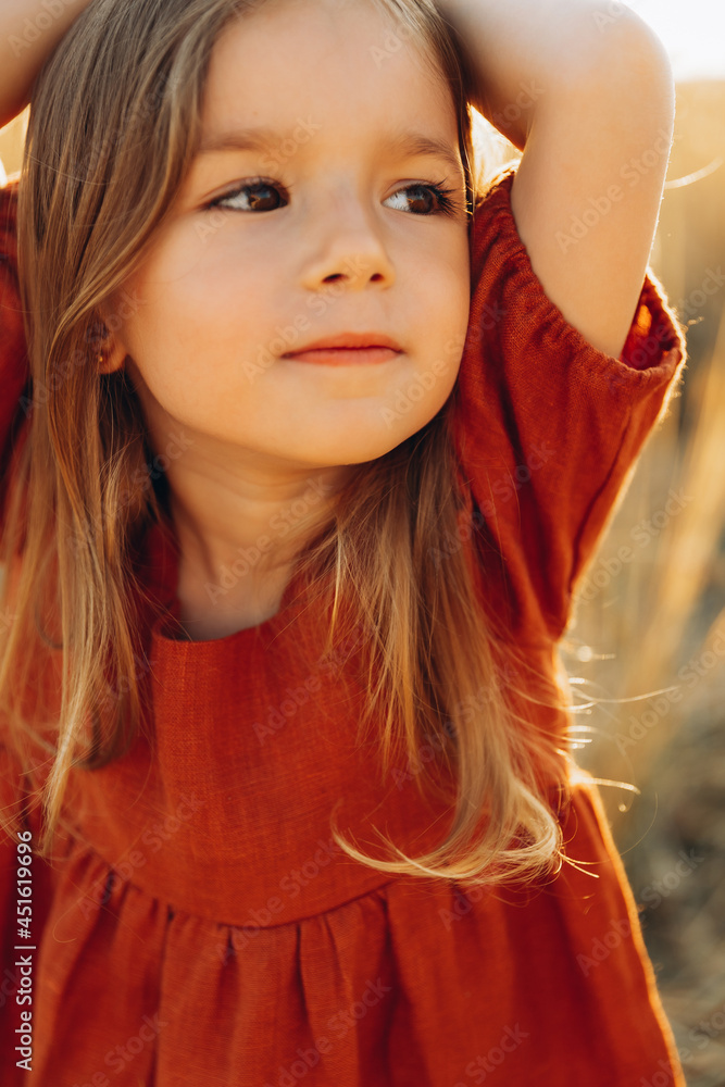 Little beautiful smiling girl on a gold wheat field. Girls in the grain ...