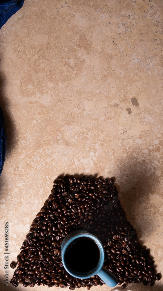taza de café azul sobre granos de café en fondo de mármol con telas ...