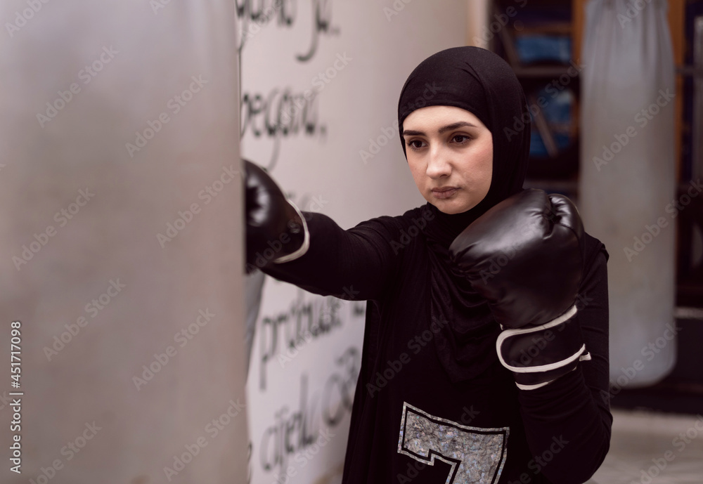 Muslim woman boxing in the boxing ring wearing boxing gloves and ...