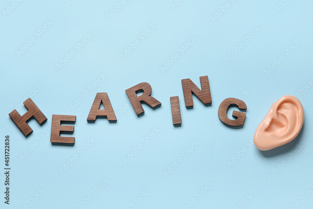 Word HEARING and model of ear on color background Stock Photo | Adobe Stock