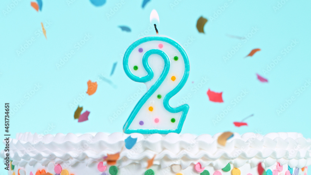 Colorful tasty birthday cake with candles shaped like the number 2 ...
